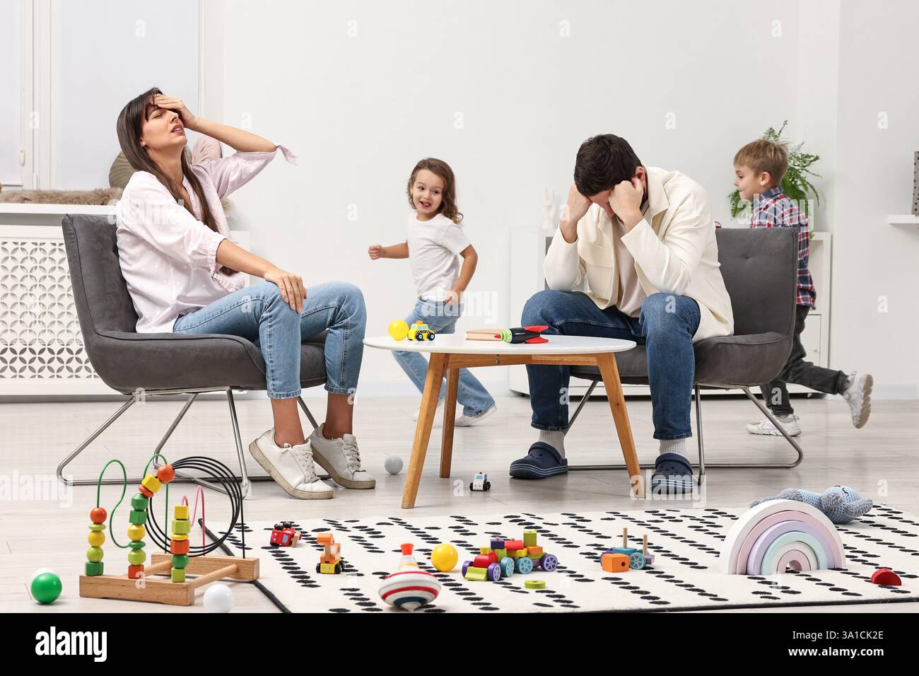 Hyperactive children playing and their overwhelmed parents at home ...
