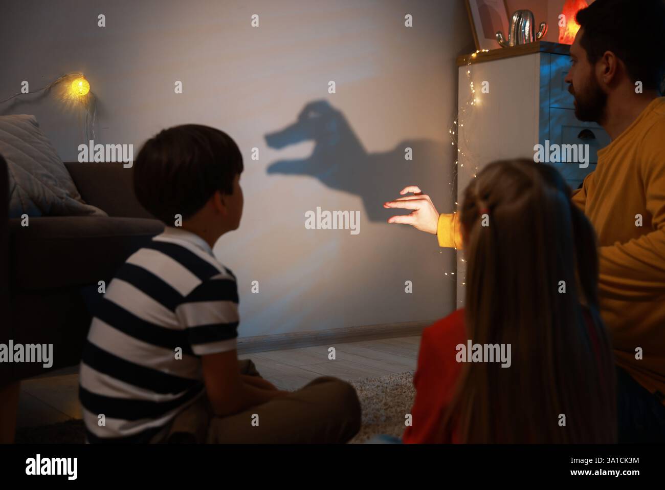 Man making hand gesture like goose while performing shadow play to his ...