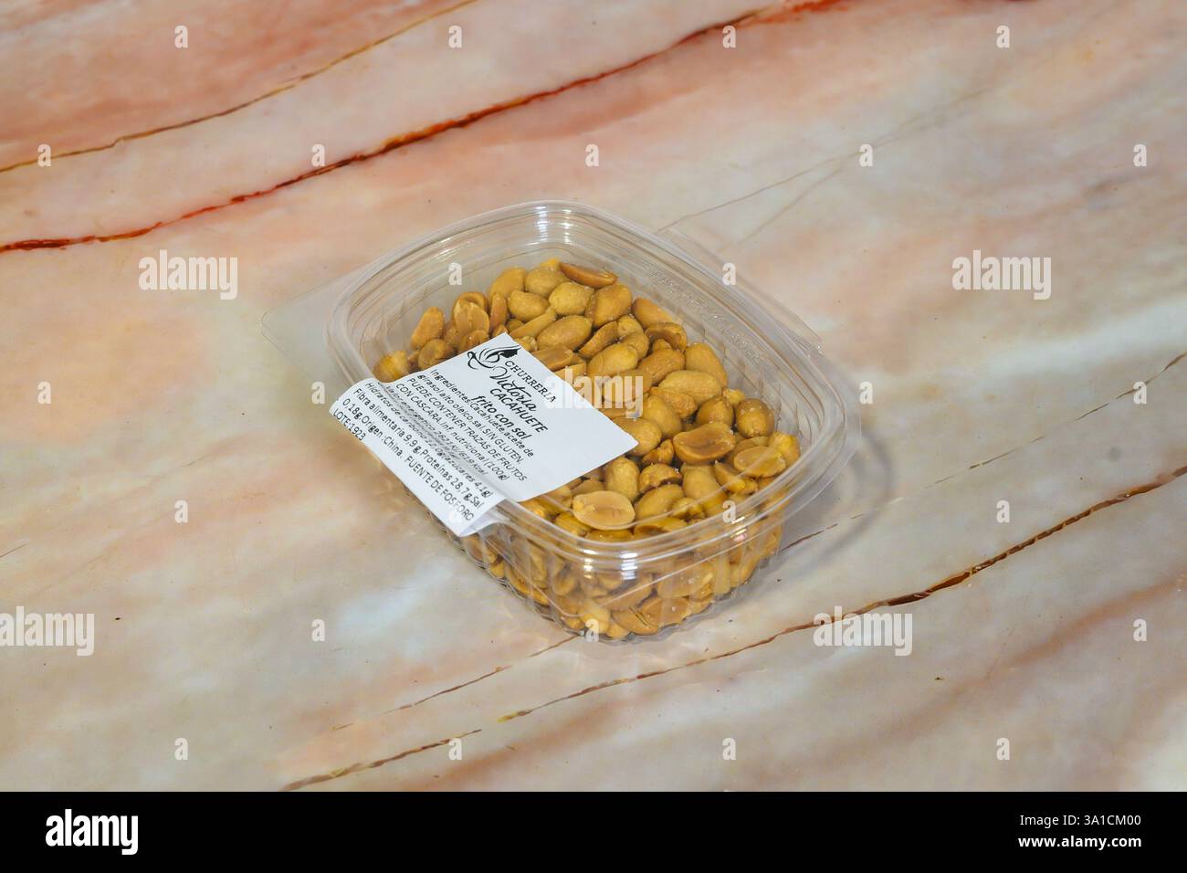 A bag of peanuts sits on a marble countertop. The peanuts are in a ...