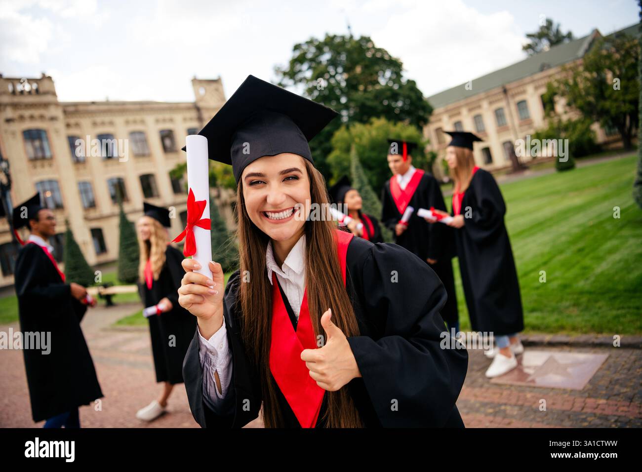 Joyful graduates celebrating their success with diplomas and smiles on ...