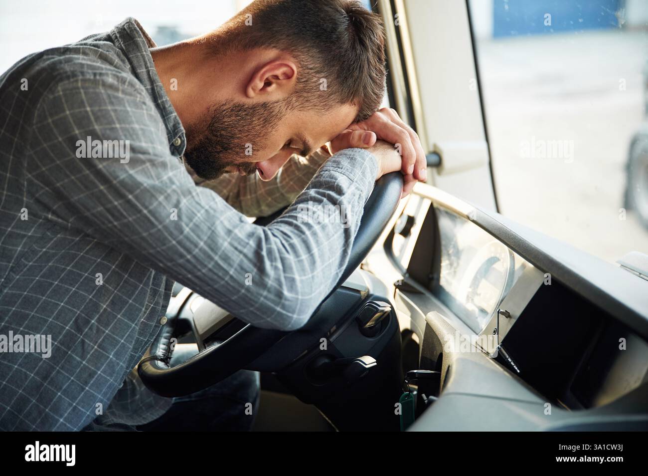 Sitting inside, tired. Young truck driver in casual clothes Stock Photo ...