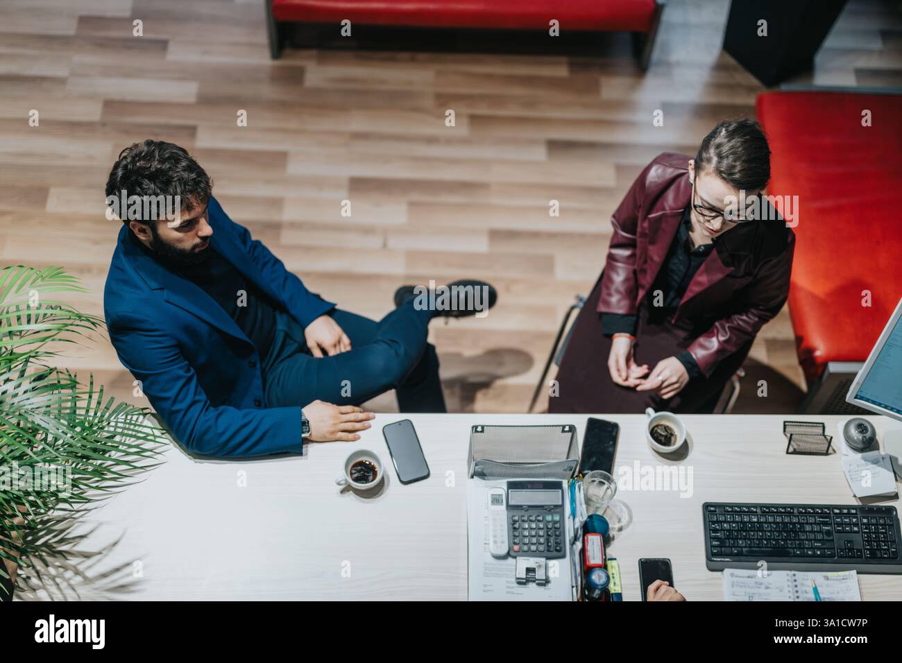 Two people having a conversation at an office desk setting Stock Photo ...