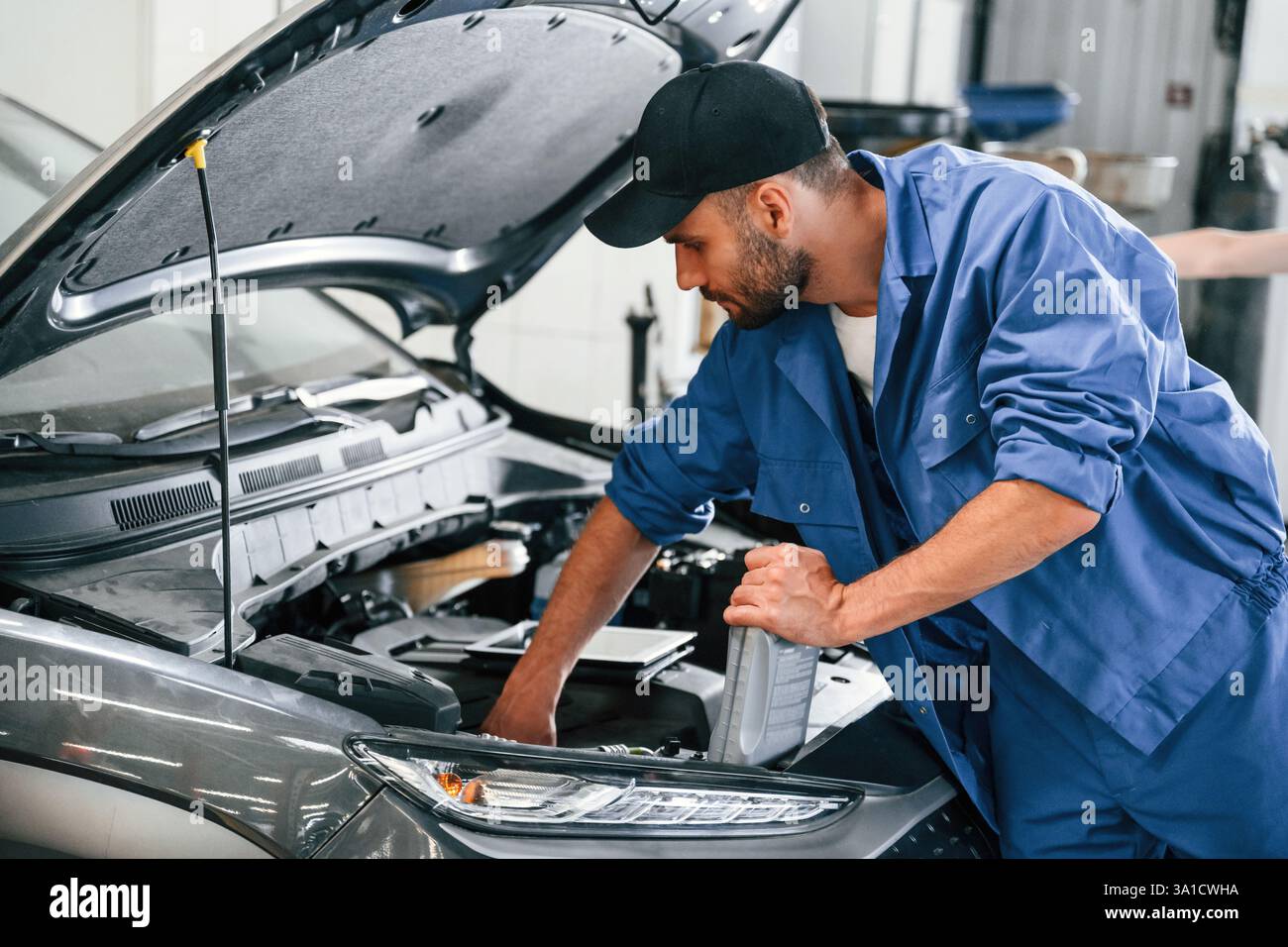 Process of changing the oil. Auto mechanic working in garage. Repair ...