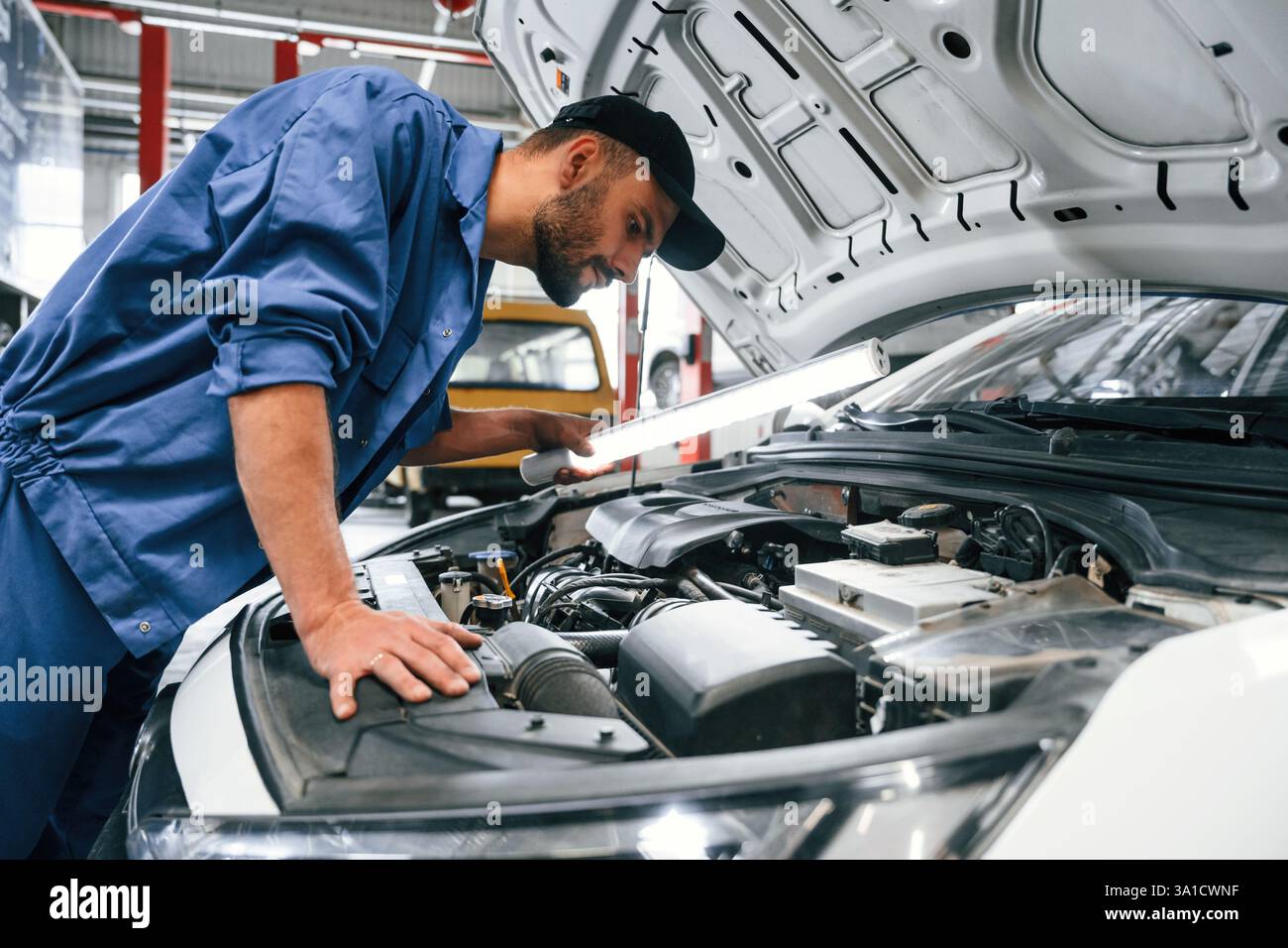 Troubleshooting process. Auto mechanic working in garage. Repair ...