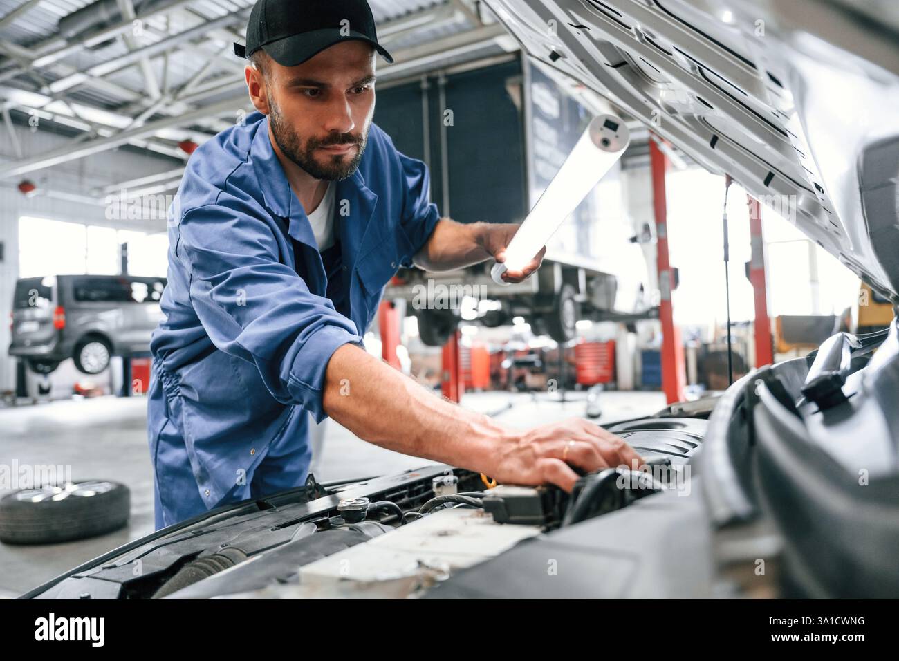 Troubleshooting process. Auto mechanic working in garage. Repair ...