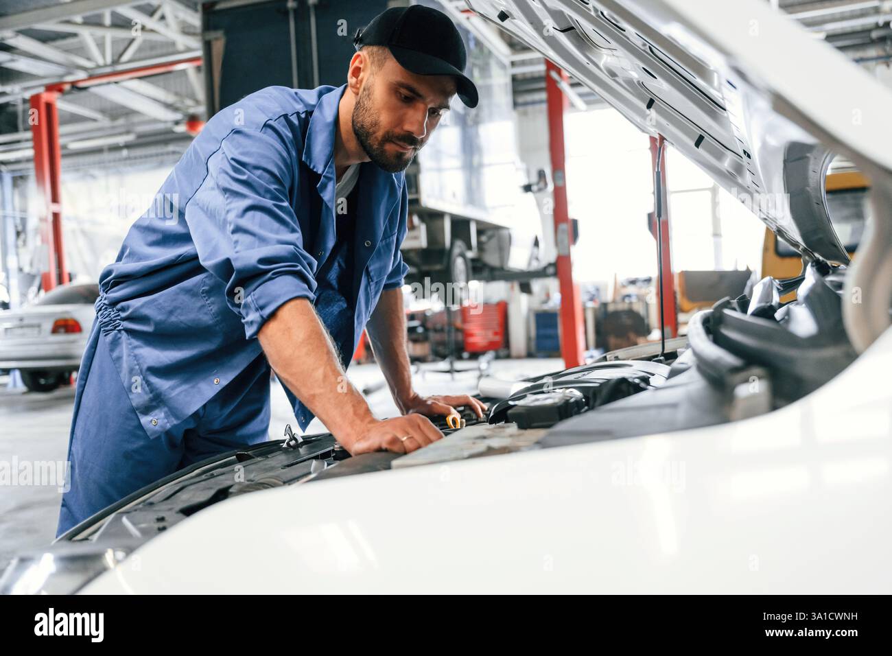 Troubleshooting process. Auto mechanic working in garage. Repair ...