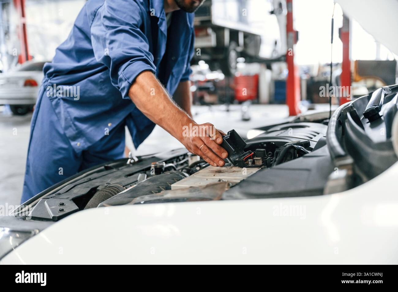 Troubleshooting process. Auto mechanic working in garage. Repair ...