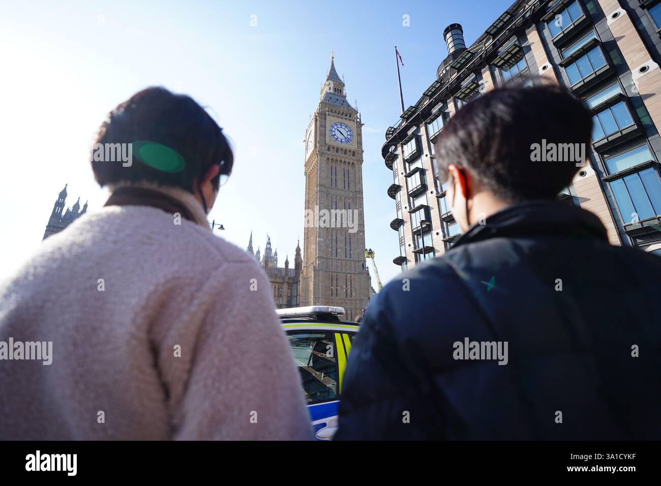 People watch a man with a Palestine flag after he climbed up Elizabeth ...