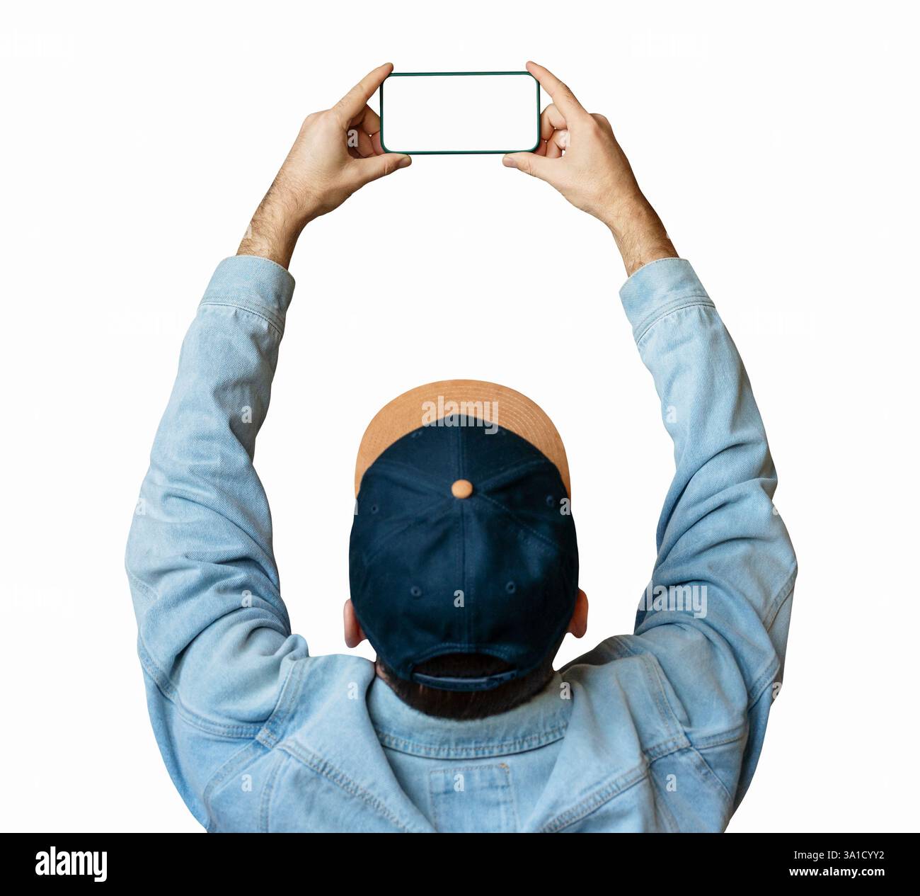 Man in denim jacket and cap holding smartphone above head with raised ...