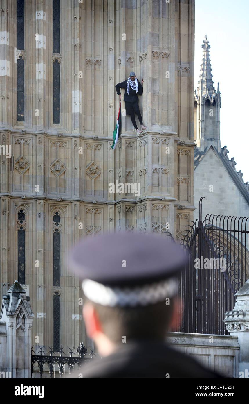 March 8, 2025, London, England, UK: A protester clings on to the ...