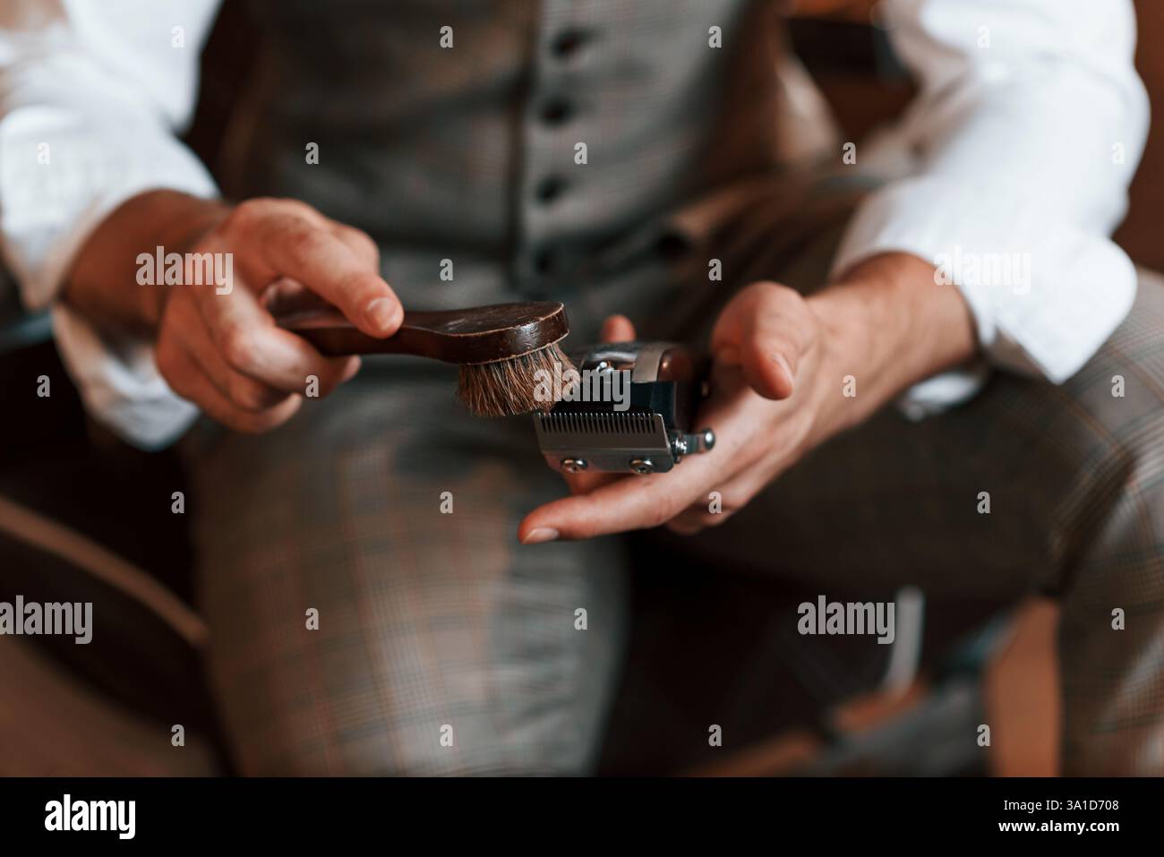 Cleaning hair clipper. Handsome barber is in the salon Stock Photo - Alamy