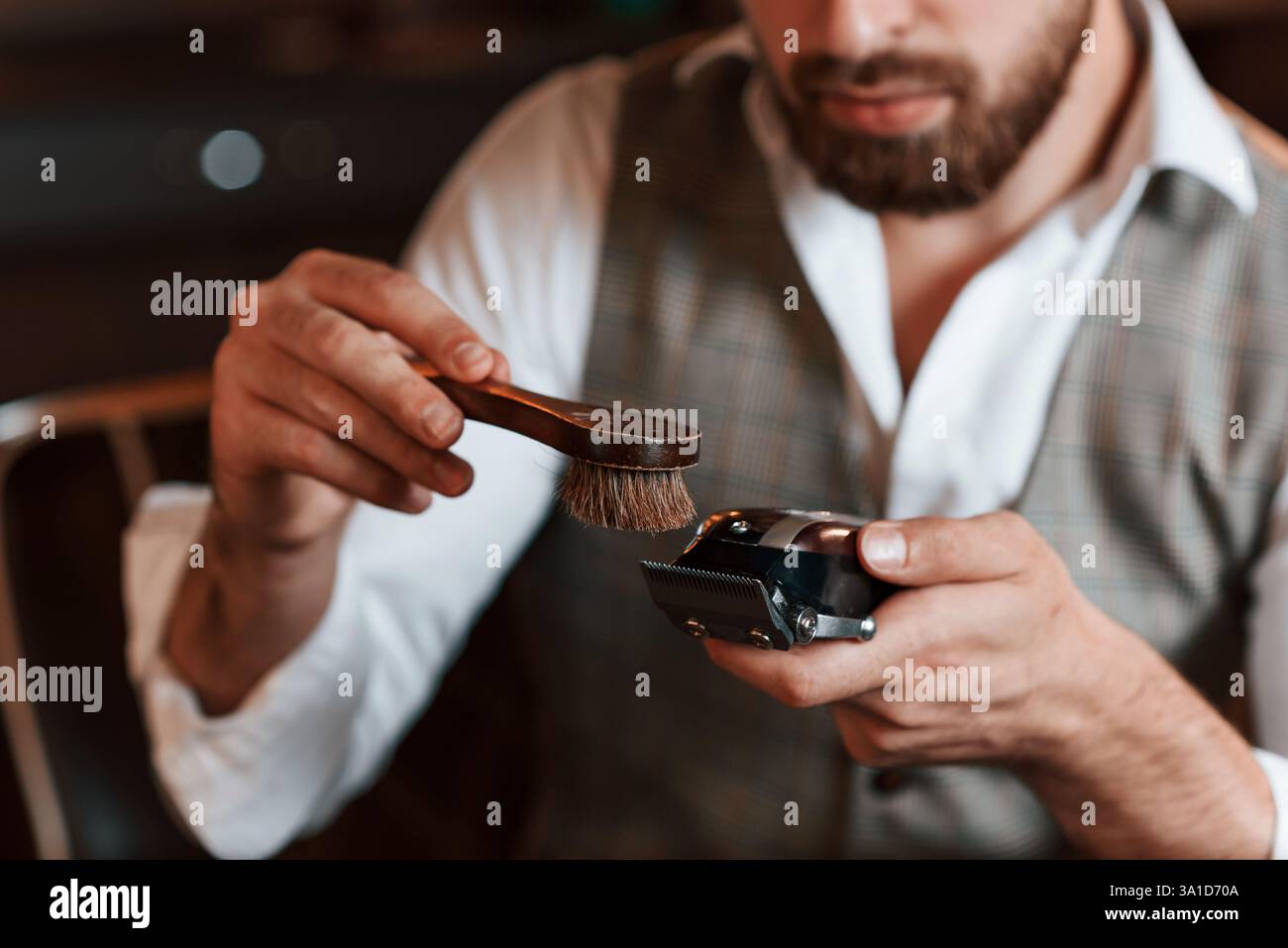 Cleaning hair clipper. Handsome barber is in the salon Stock Photo - Alamy