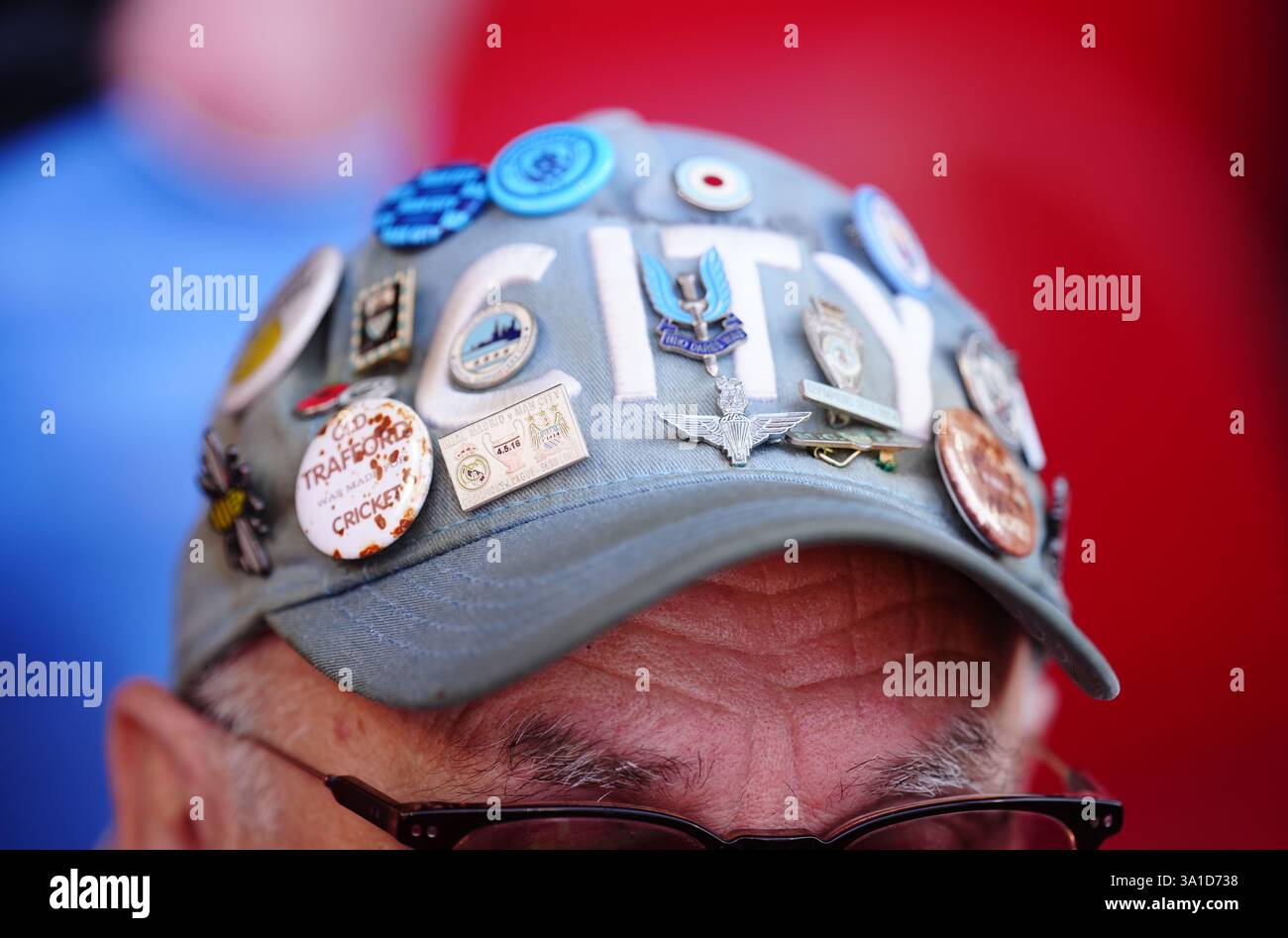 Pin badges on the cap of a Manchester City fan before the Premier ...