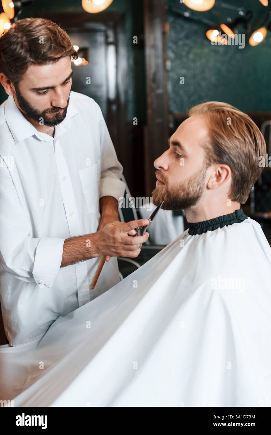 Using scissors. Man is visiting modern barber shop. Modern style Stock ...