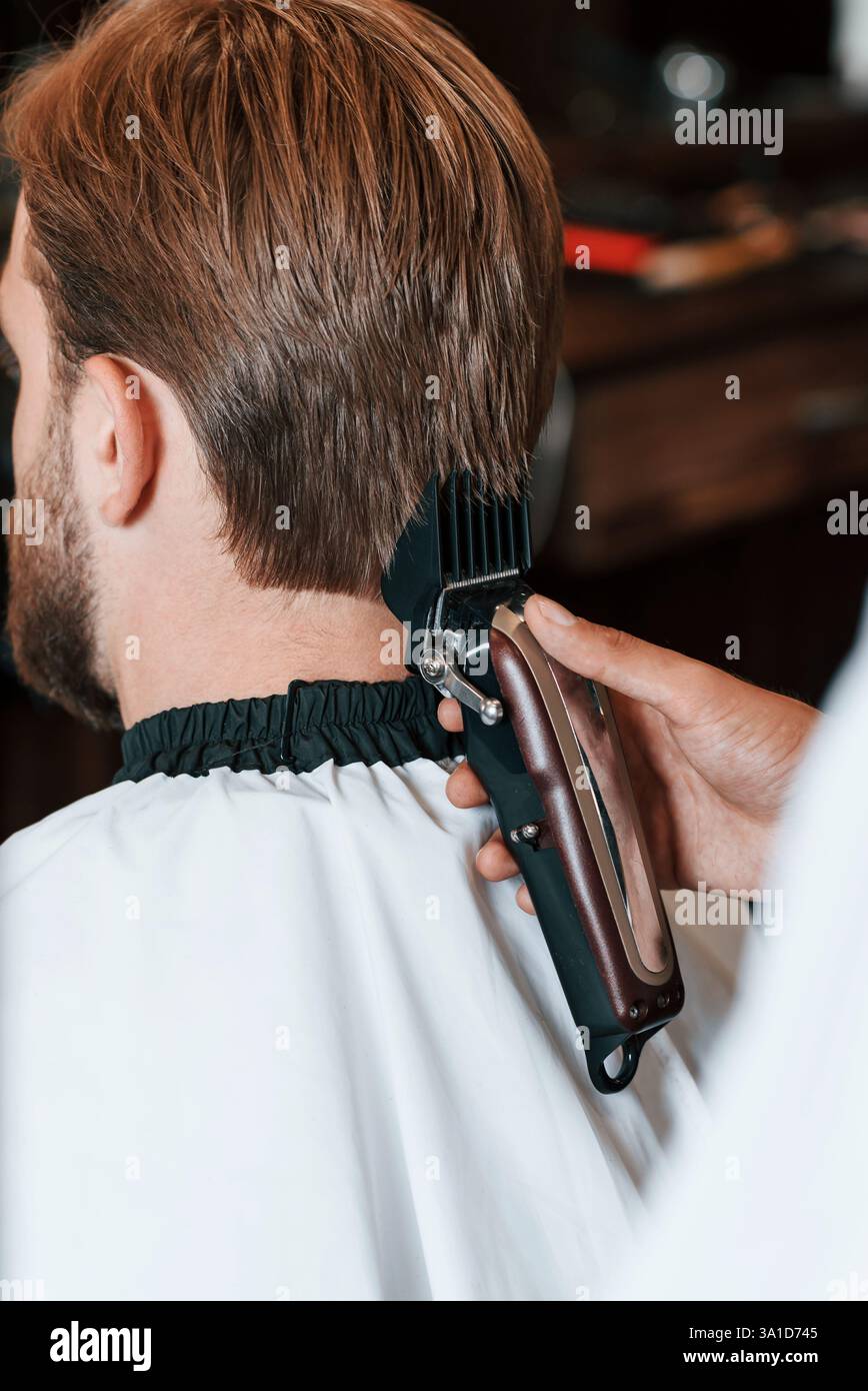 Rear view. Man is visiting modern barber shop. Modern style Stock Photo ...