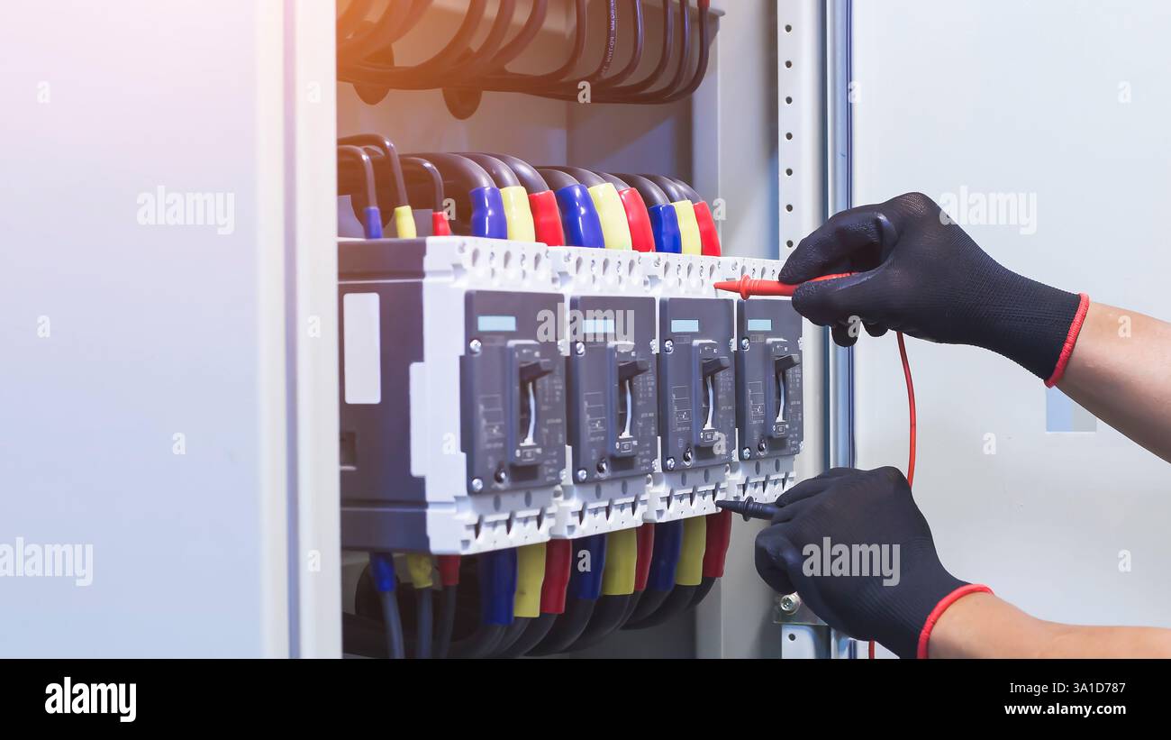 Electrical engineer tests the operation of the electric control cabinet ...