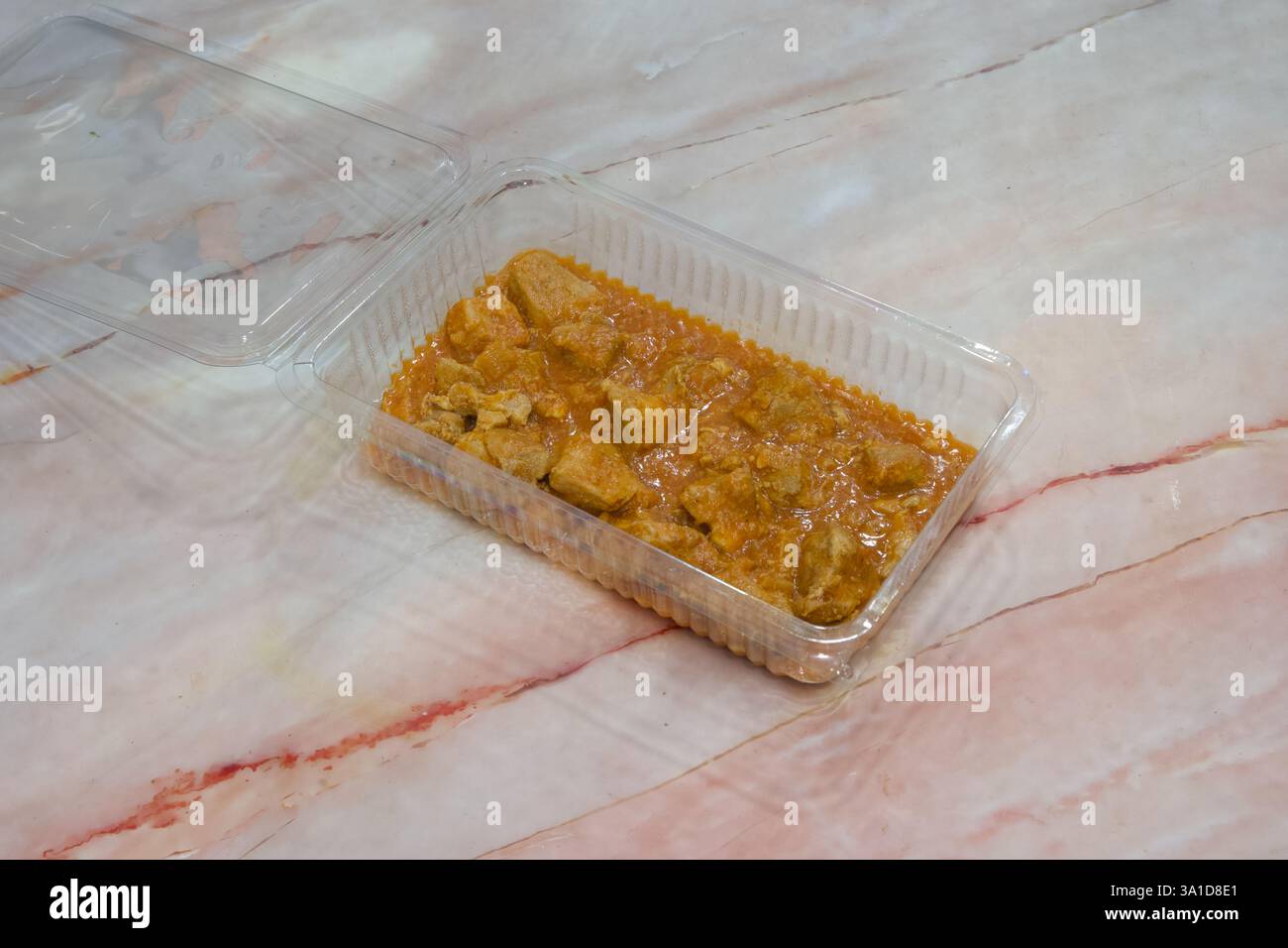 A container of food with a lid on top. The lid is open and the food is ...