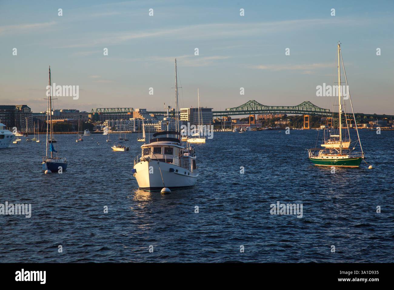 Sailboats at sunset, cranes and the buildings at the waterfront, Boston ...