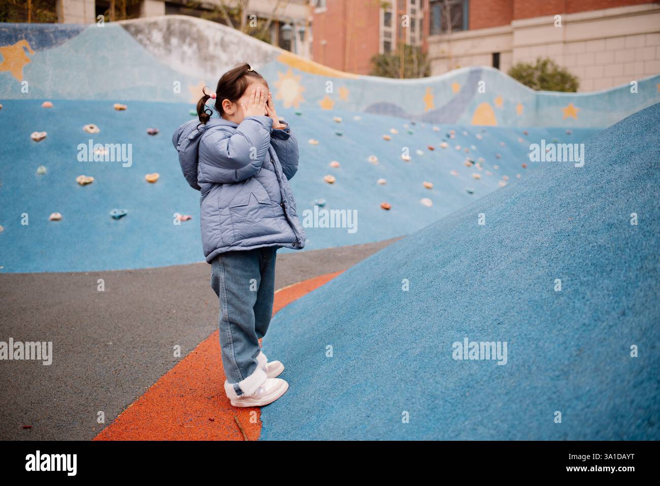 Small Chinese girl playing hide and seek at a local playground Stock ...