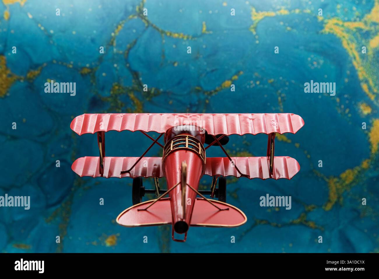 Avión biplano clásico pintado de rojo de hélice, con fondo azul ...