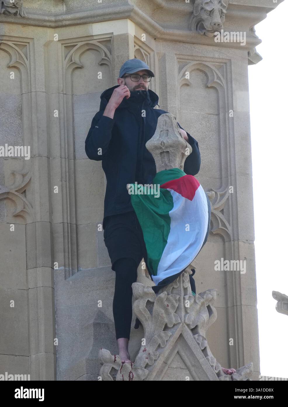 A man holds a Palestine flag after he climbed up Elizabeth Tower, which ...