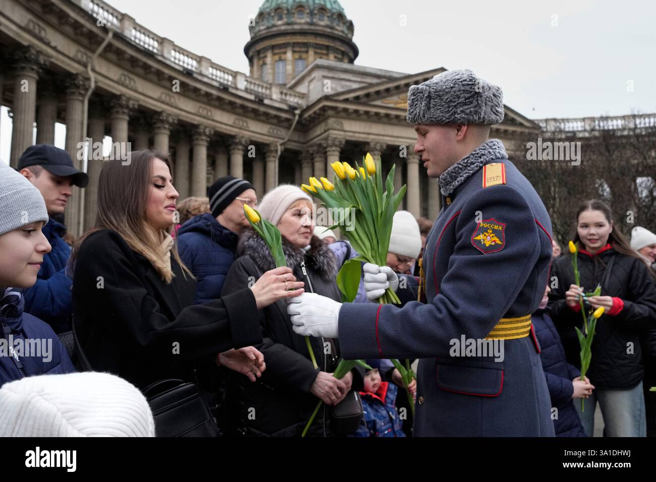 A honour guard soldier presents flowers to women during International ...