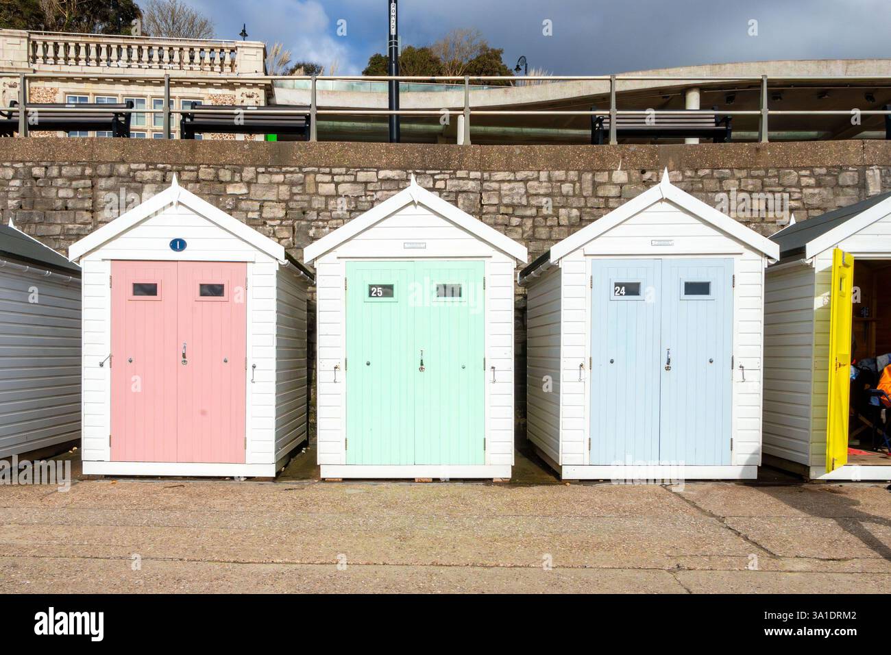 3 pastel coloured beach huts on the promenade seafront in Lyme regis ...