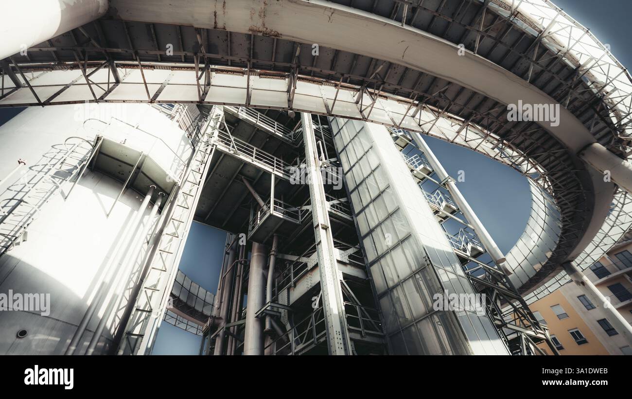 Industrial metal structure with spiral walkways, staircases, pipes, and ...