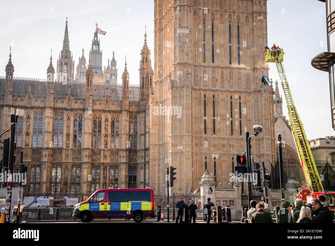 London, UK. 8th Mar, 2025. Emergency responders talk to a man climbing ...