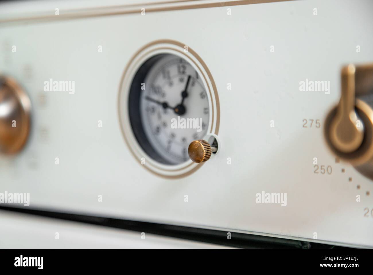 A white oven with a clock on the front. The clock is set to 12:00. The ...