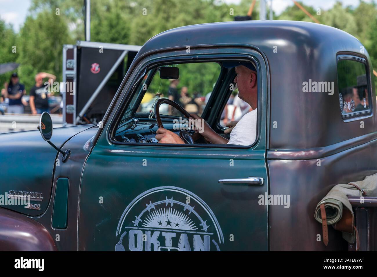 A racer behind the steering wheel of a Chevrolet pickup truck waits for ...