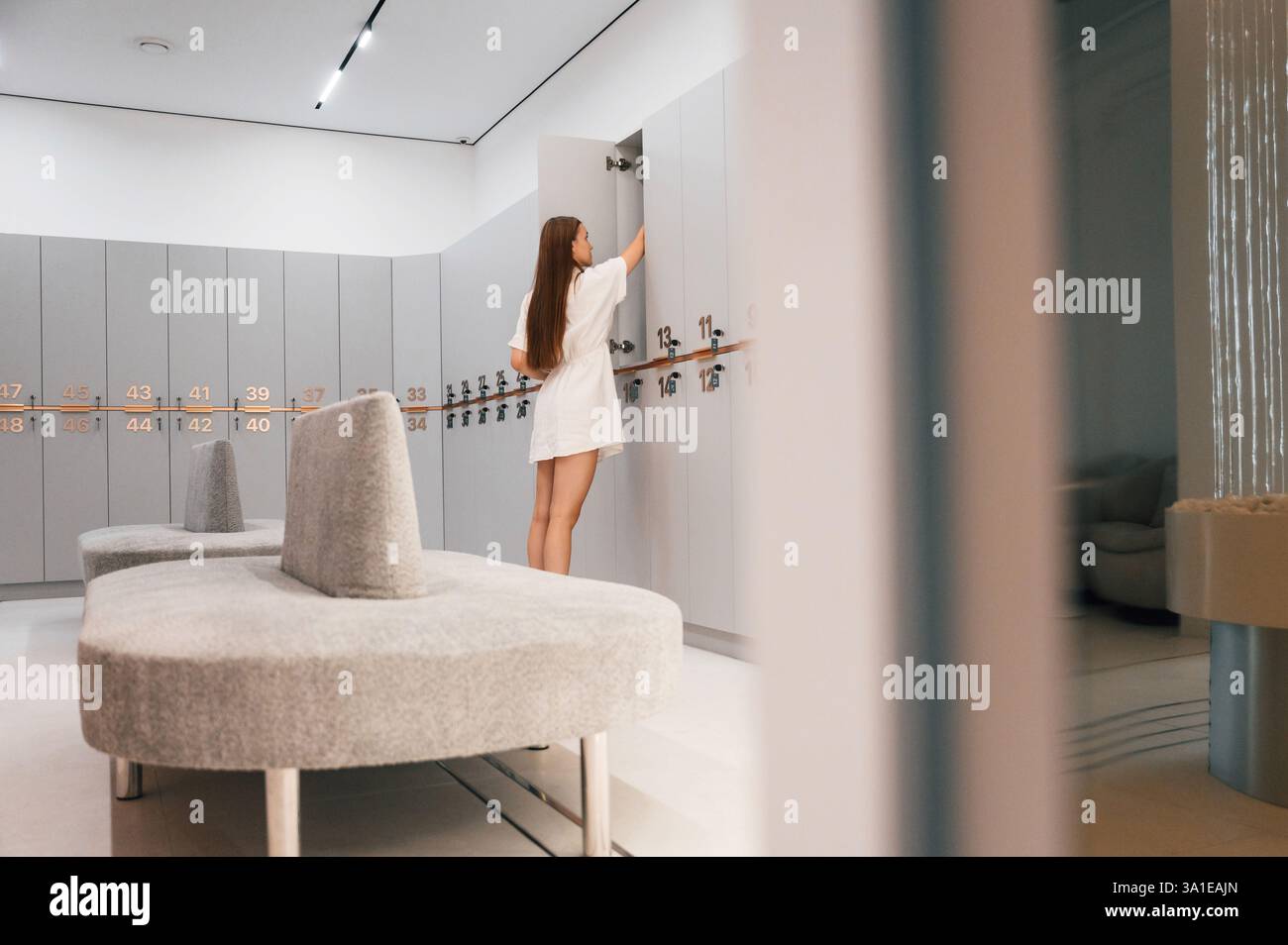 Woman is in the gym changing room with lockers Stock Photo - Alamy
