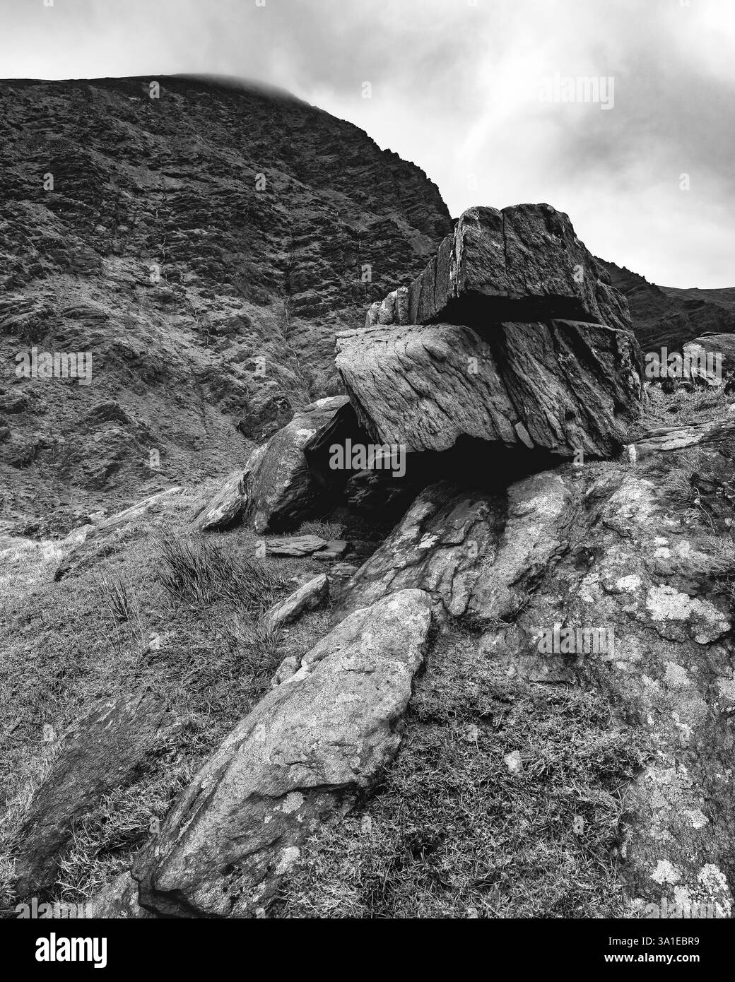 The photograph captures a prominent rock structure in a hilly region ...