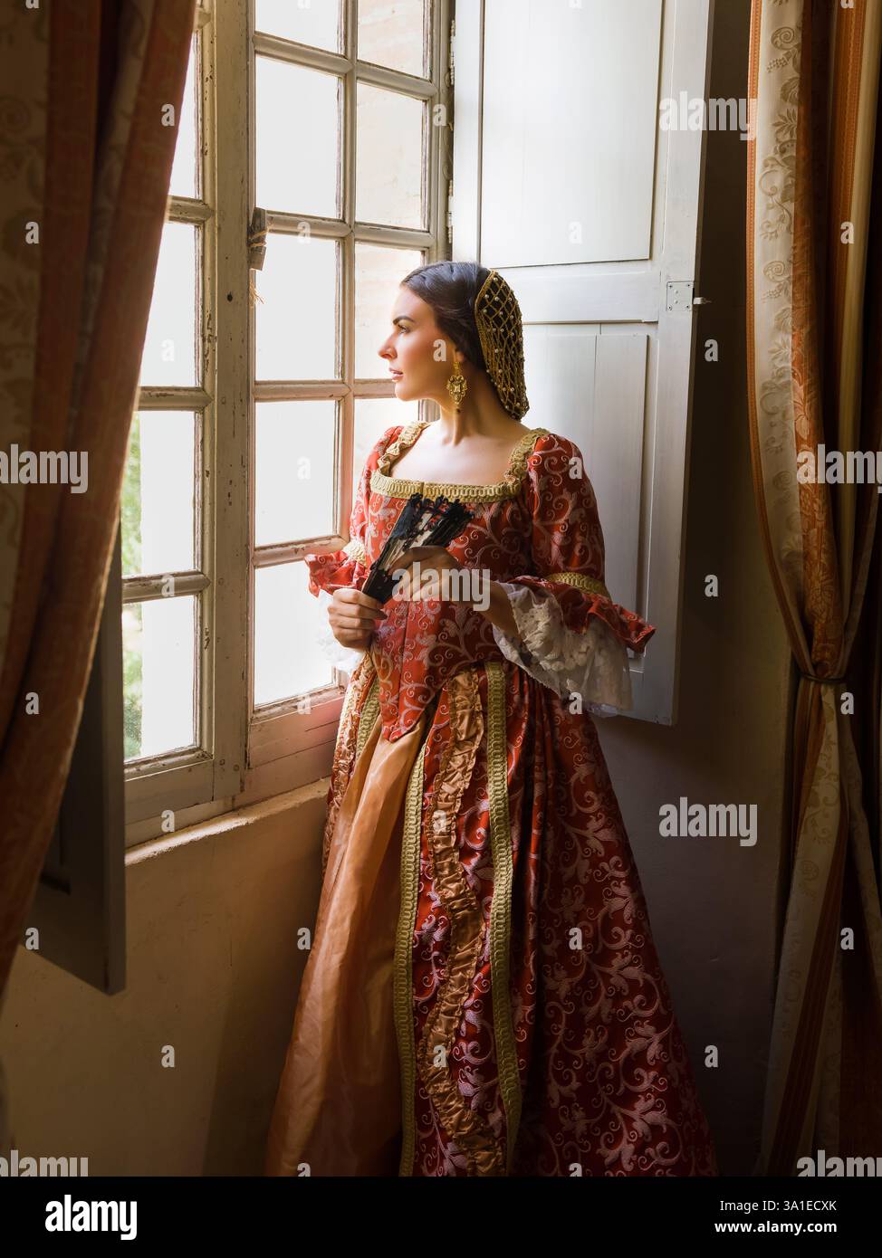 Woman wearing authentic Renaissance costome and headdress standing at ...