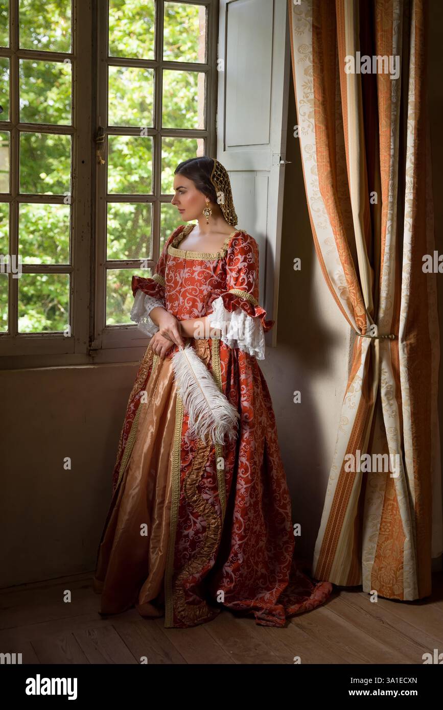 Woman wearing authentic Renaissance costome and headdress standing at ...