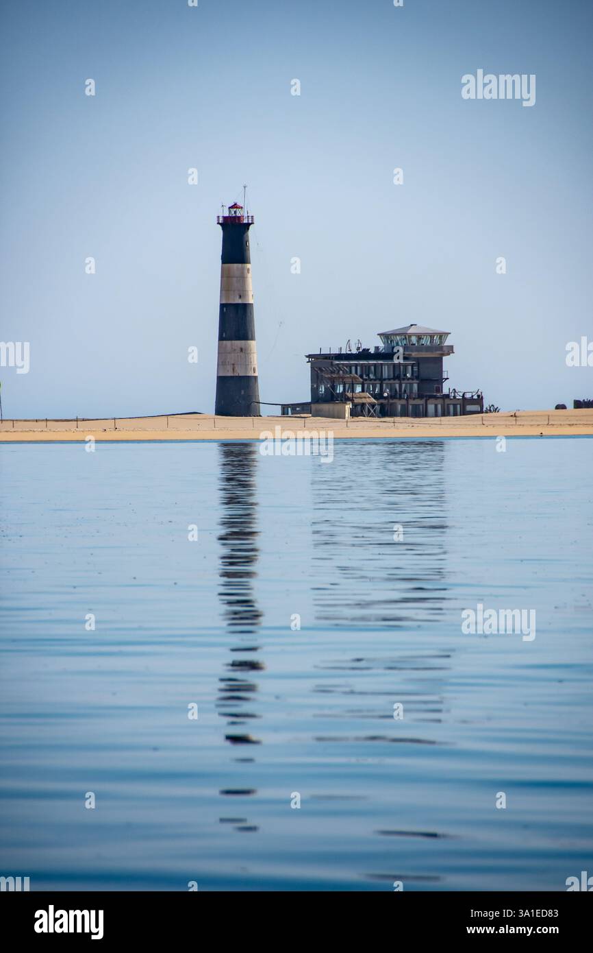 Reflection of Pelican Point lighthouse in water at Walvis Bay, Namibia ...