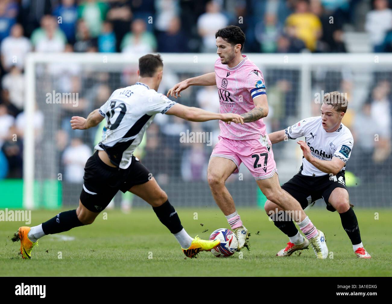 Blackburn Rovers' Lewis Travis (centre) battles for the ball with Derby ...