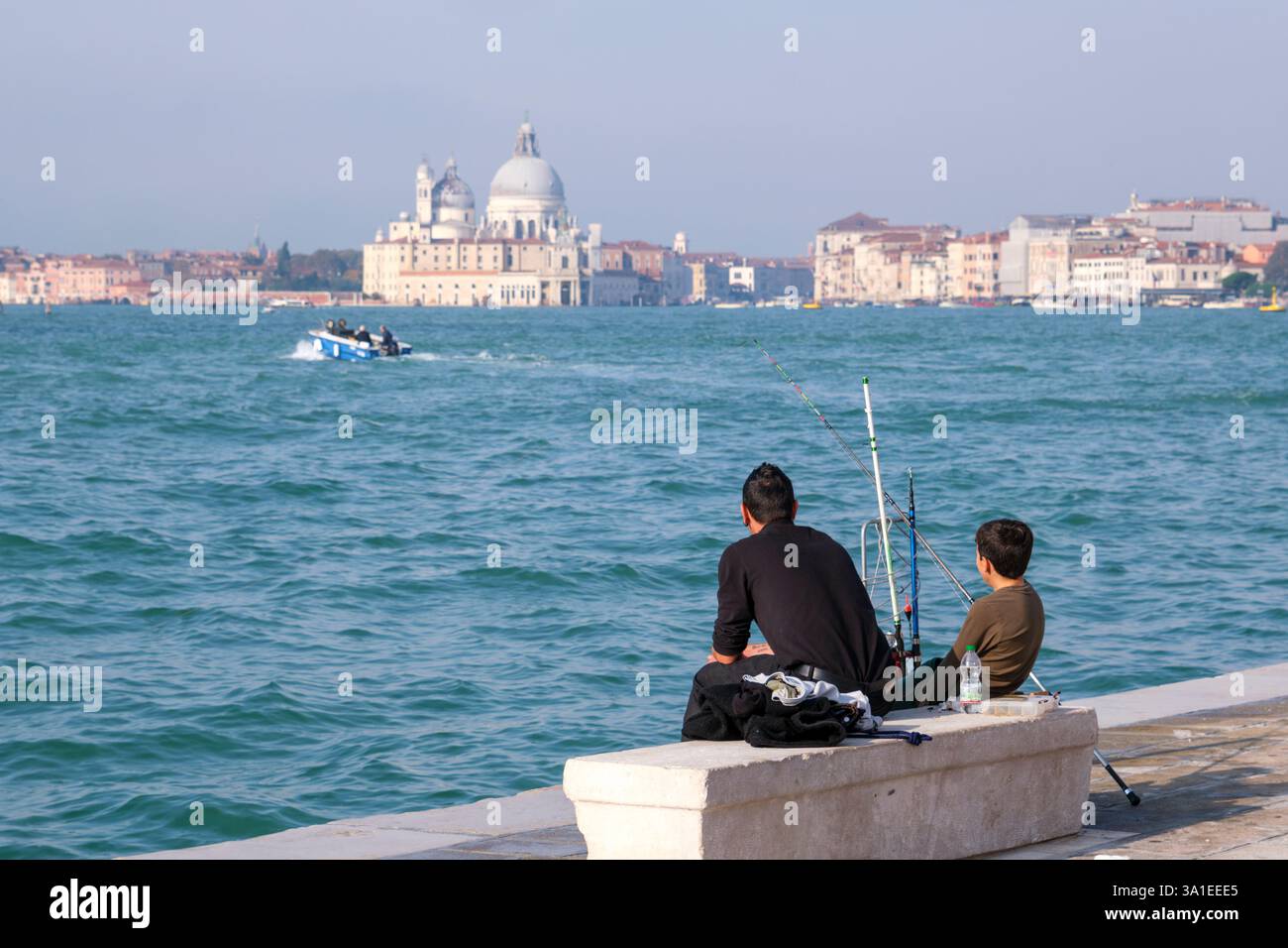 Venice, Italy - 12 October 2024: a father and his son fish near the ...
