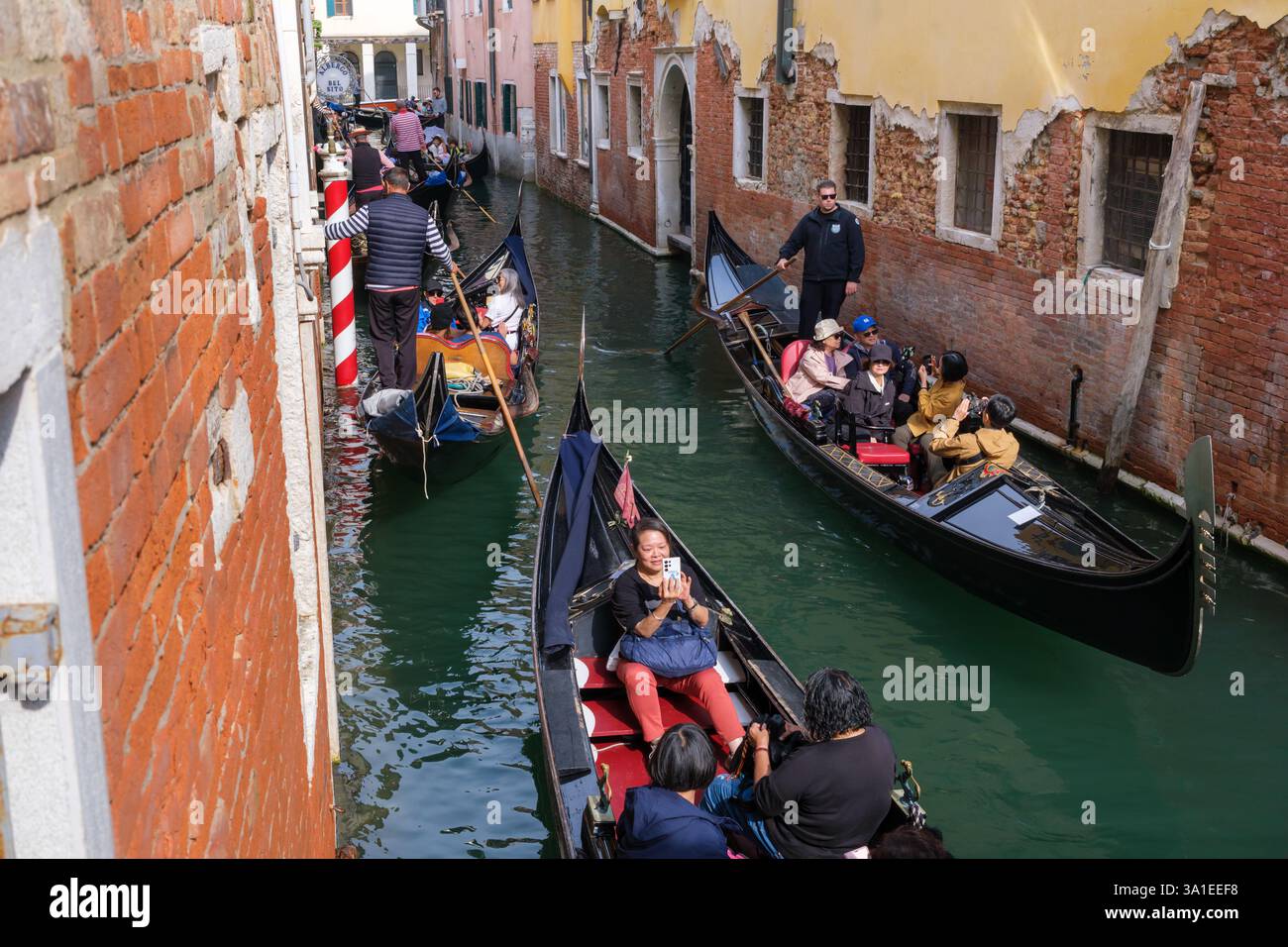 Venice, Italy - 12 October 2024: Gondolas crowd a narrow canal as ...