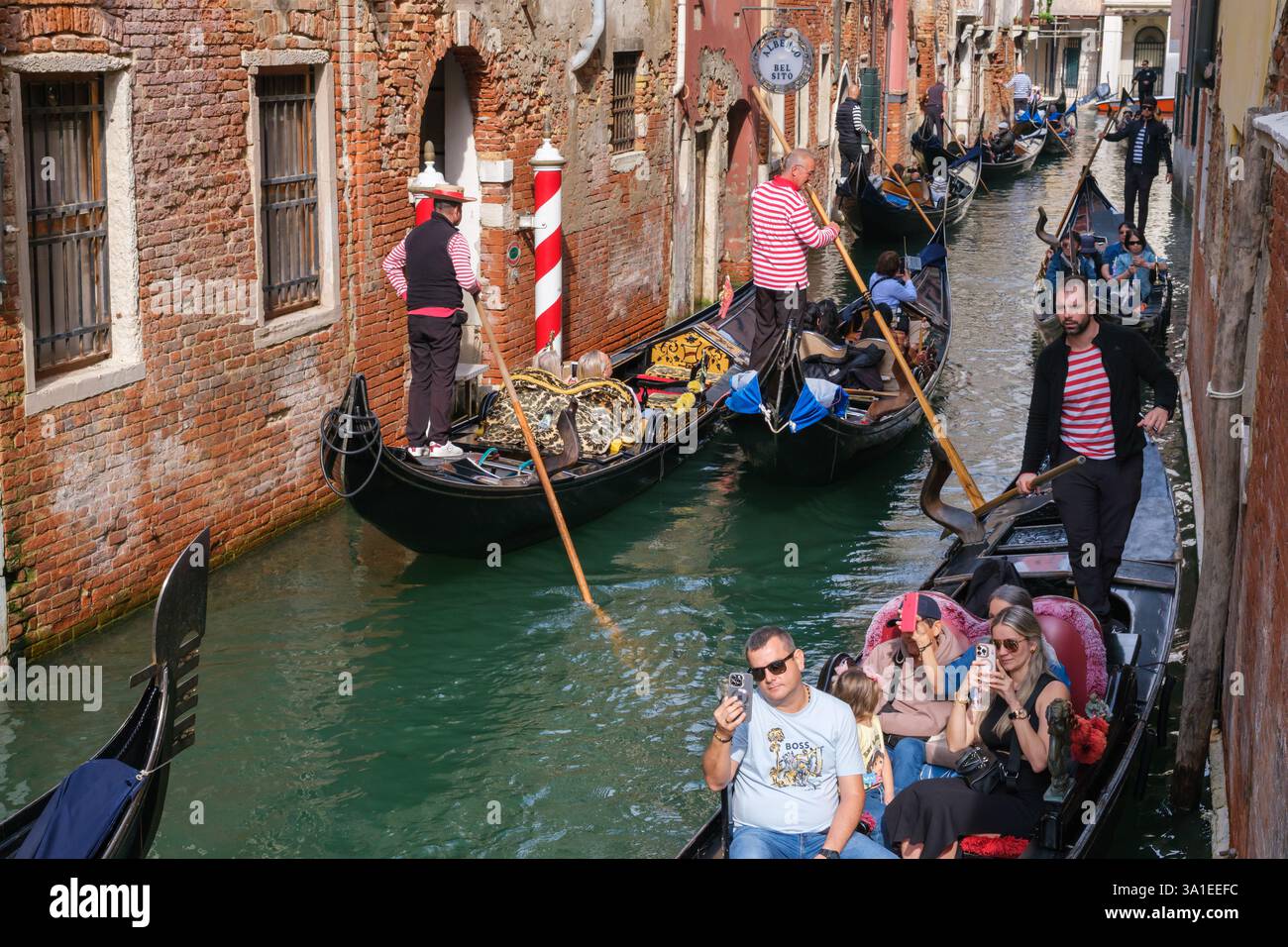 Venice, Italy - 12 October 2024: Gondolas crowd a narrow canal as ...