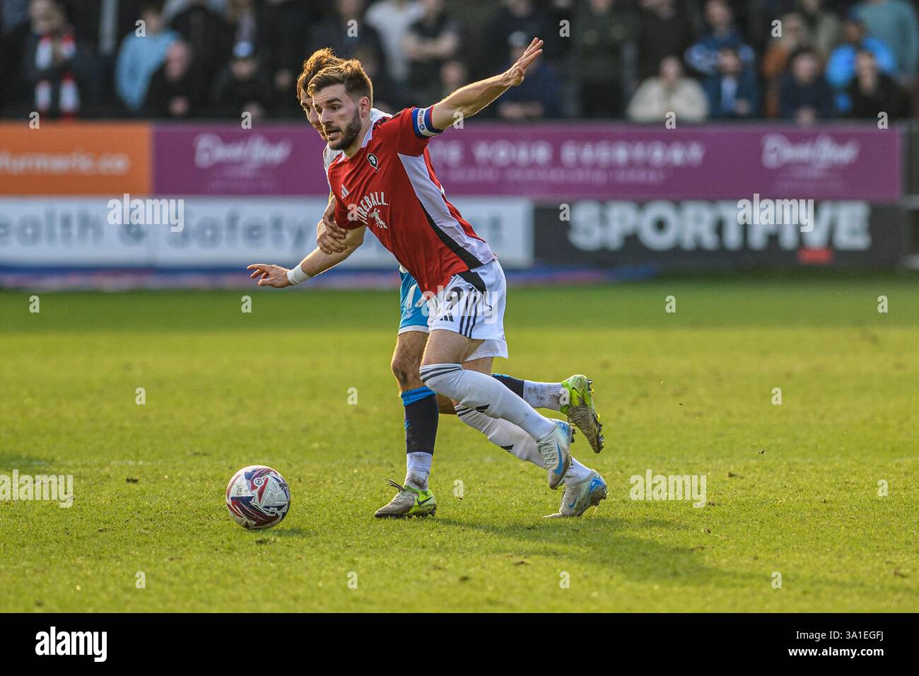 Luke Garbutt of Salford City FC under pressure from Matúš Holíček of ...