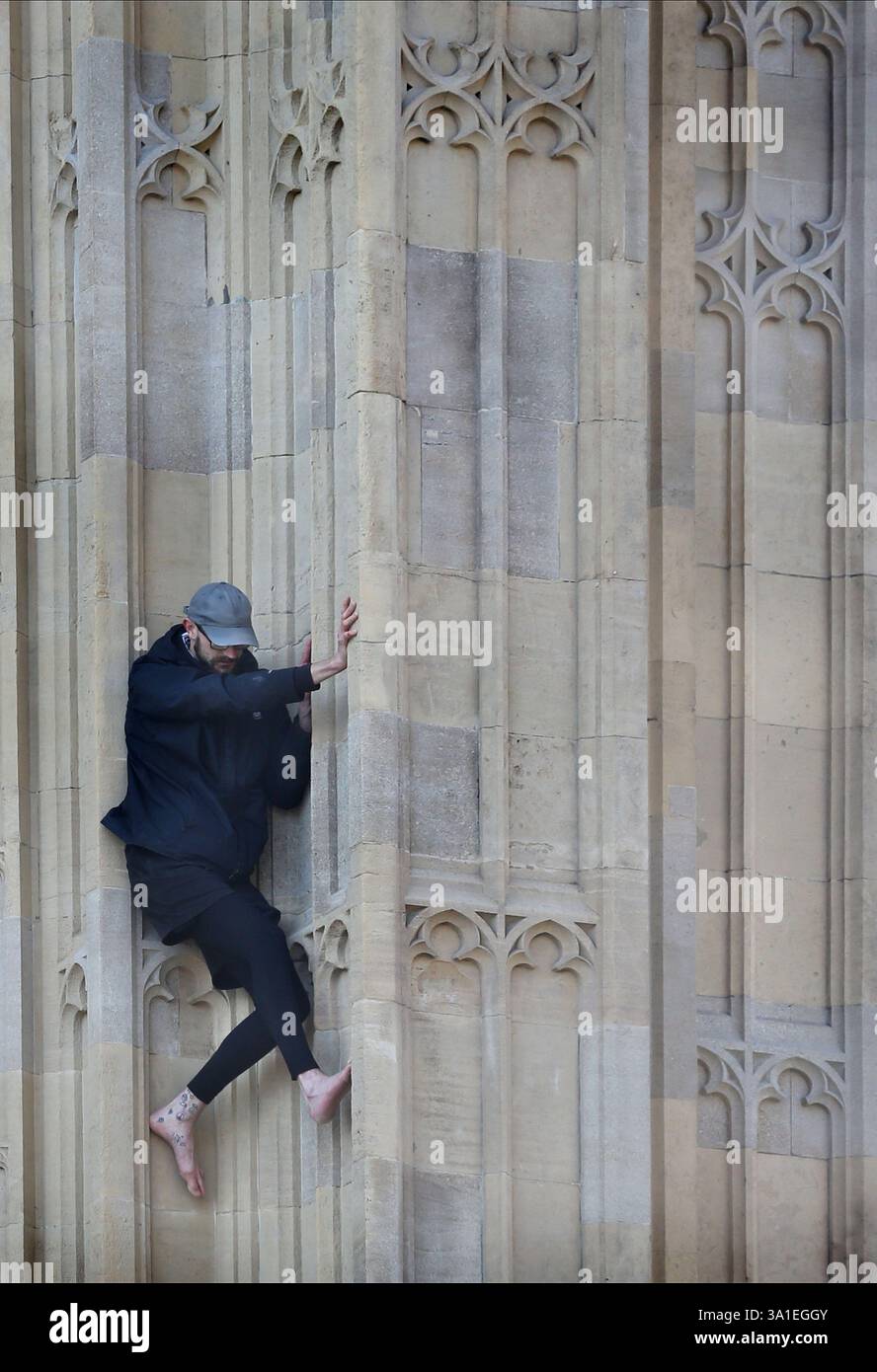 March 8, 2025, London, England, UK: A protester climbs higher, barefoot ...