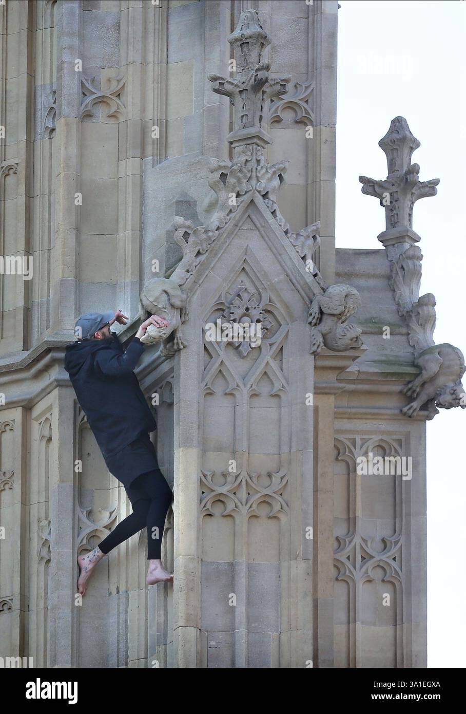 London, England, UK. 8th Mar, 2025. A protester climbs higher, barefoot ...