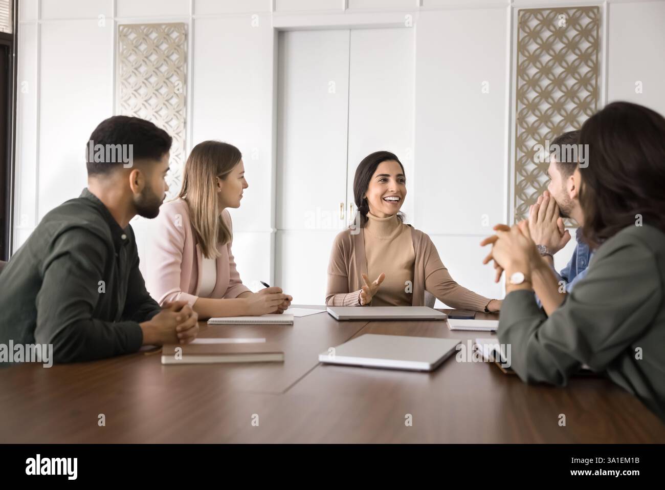 Professional team engaged in collaborative discussion around conference ...