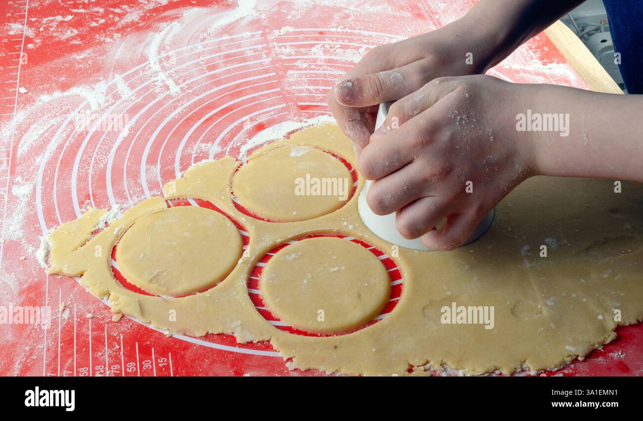Person hand cutting red cookie hi-res stock photography and images - Alamy