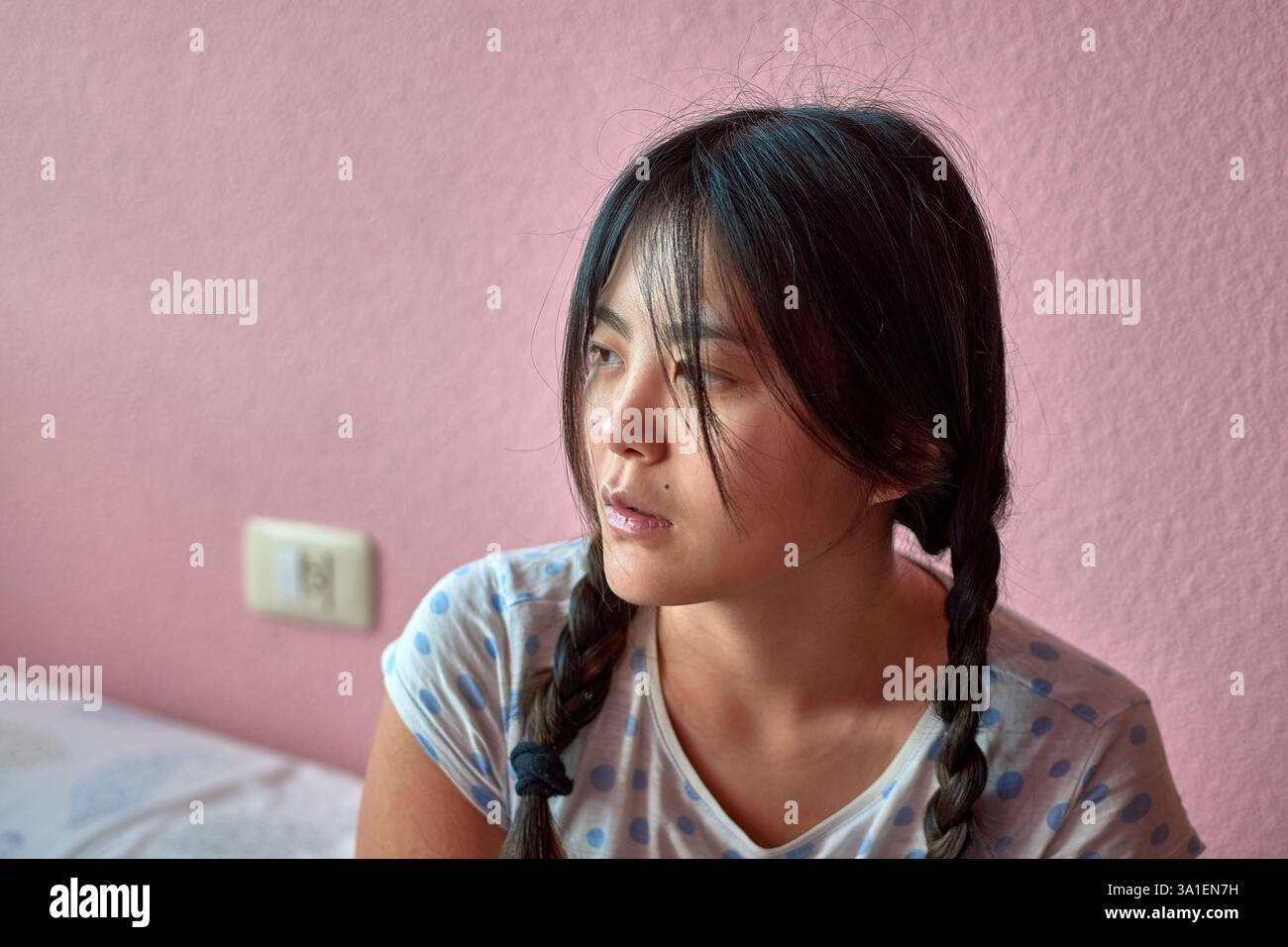 A young Chinese woman with autism in a moment of introspection, gazing ...