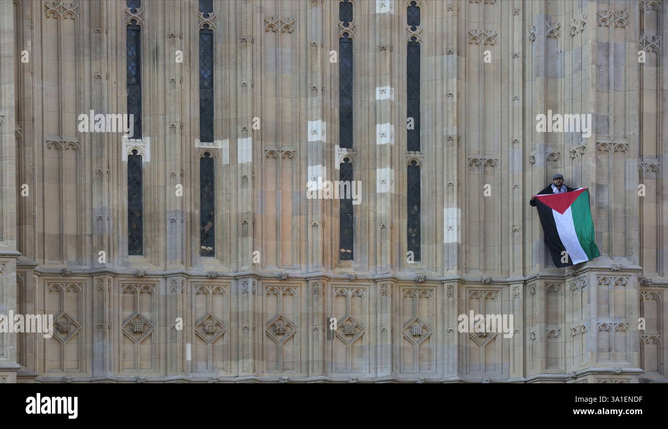 March 8, 2025, London, England, UK: A protester clings on to the ...