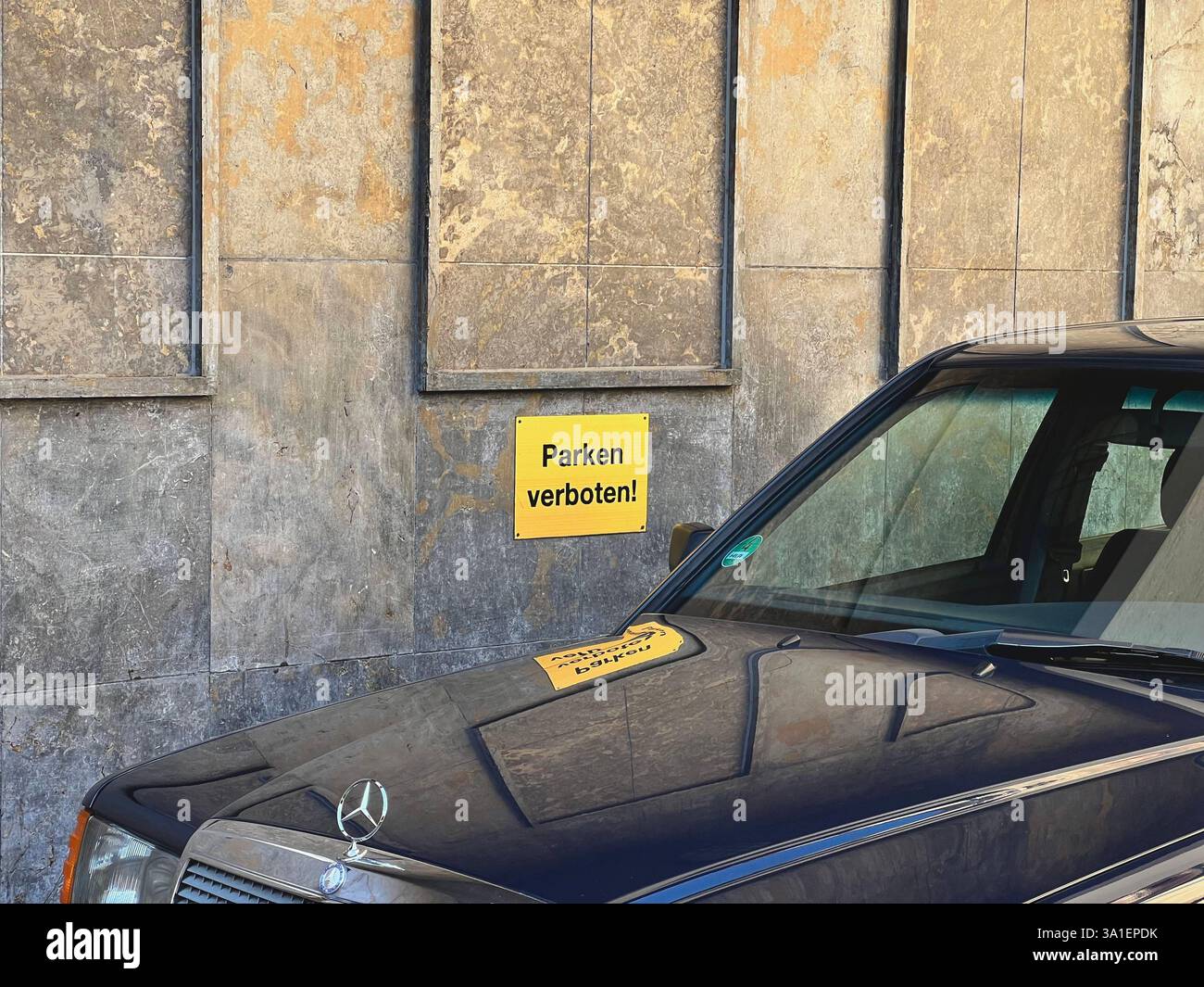 Parkverbotsschild, gelbes Schild, schwarze Schrift, Hauswand, graue ...
