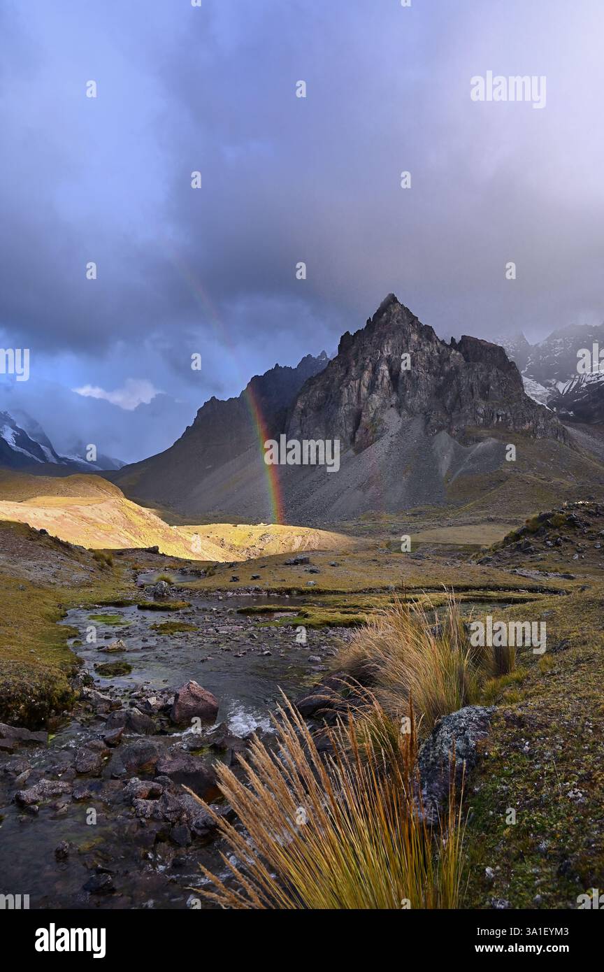 Creek and rainbow near Ausangate mountain in the Vilcanota mountain ...