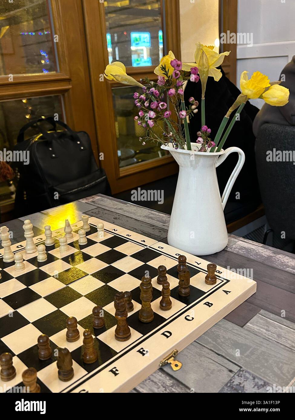 A wooden chess board on the table at the restaurant, playing brain game ...